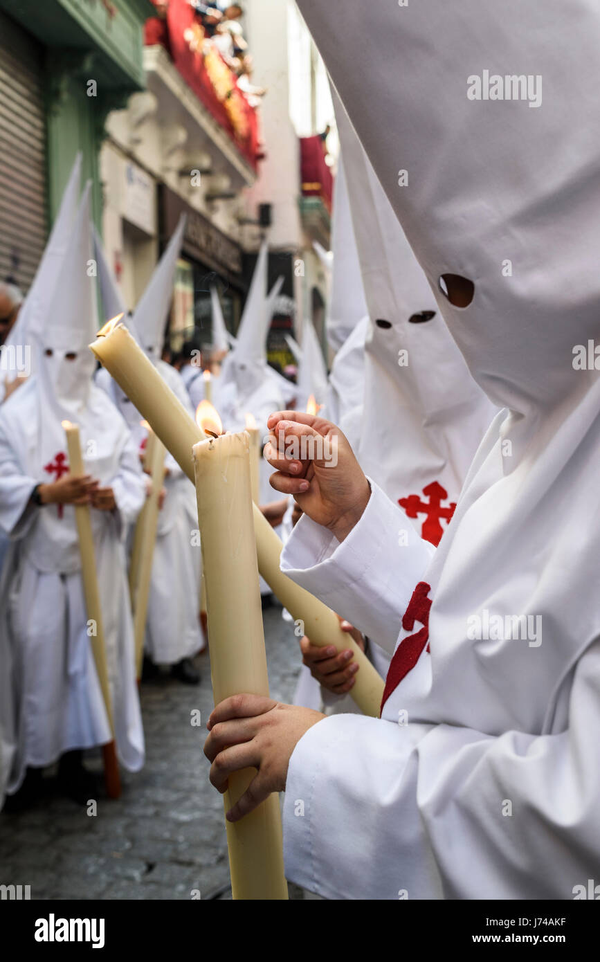 Nazarenos participating in a religious procession, with the traditional ...