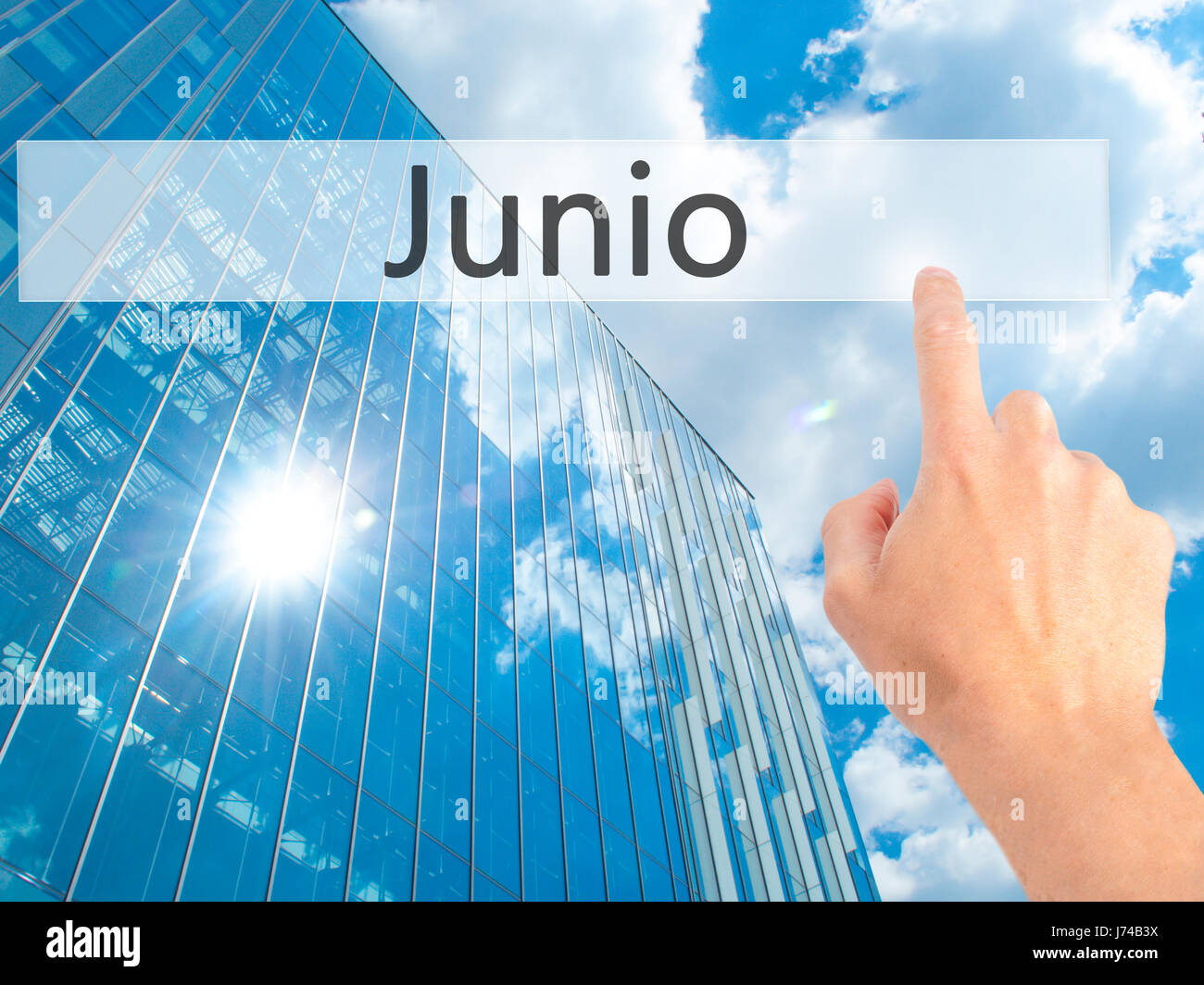 Junio (June in Spanish) - Hand pressing a button on blurred background ...