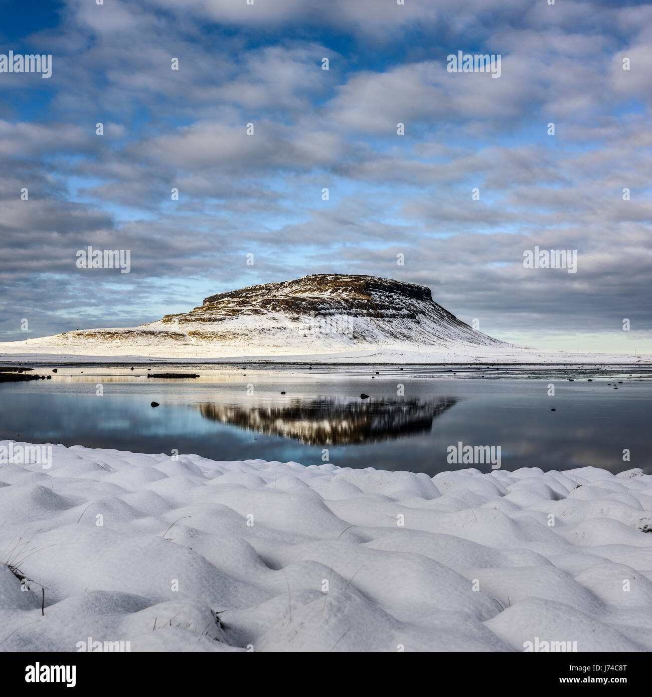 Reflection of a small mountain near Kirkjufell with a cloudy sky Stock ...