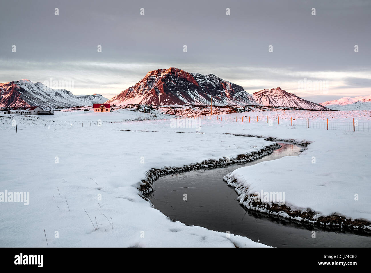 Icelandic landscape in which we can see a bunch of houses and the red ...