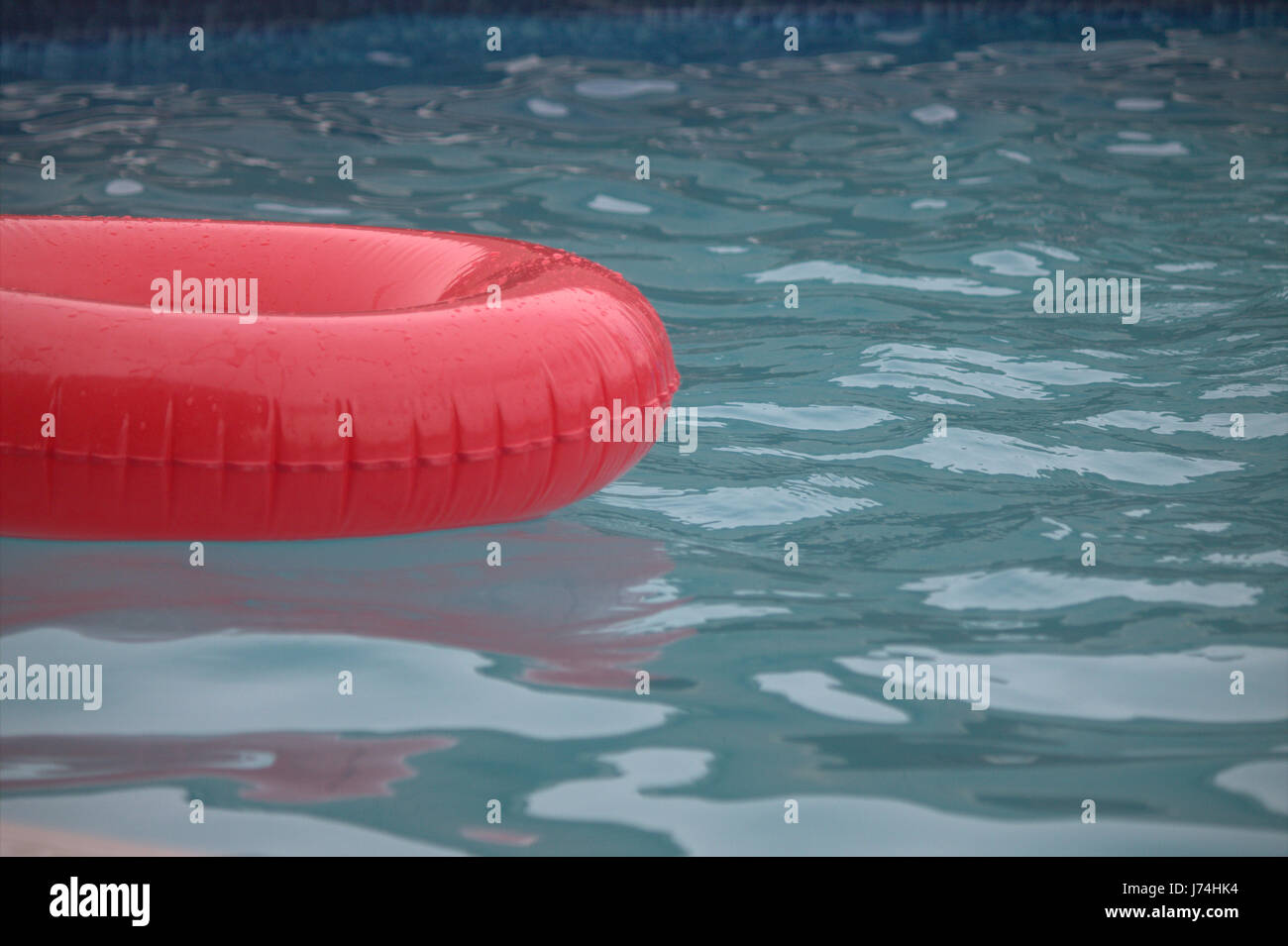 Round red float bobbing on small waves in a pool Stock Photo - Alamy