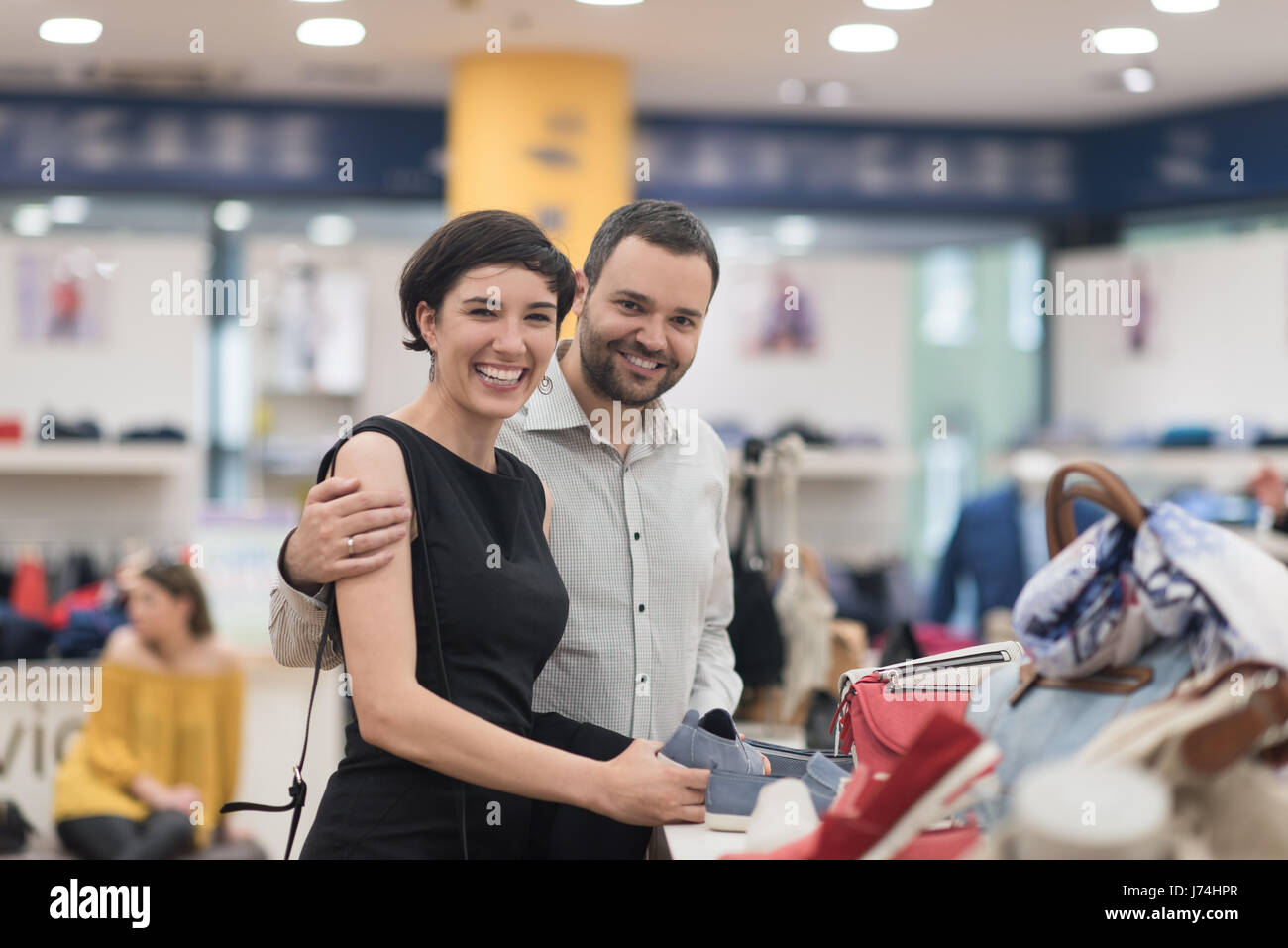 A young attractive couple changes the look with new shoes At Shoe Store ...