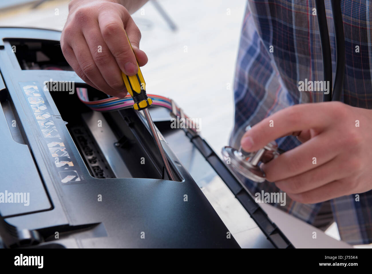 Repairman repairing broken color printer Stock Photo - Alamy