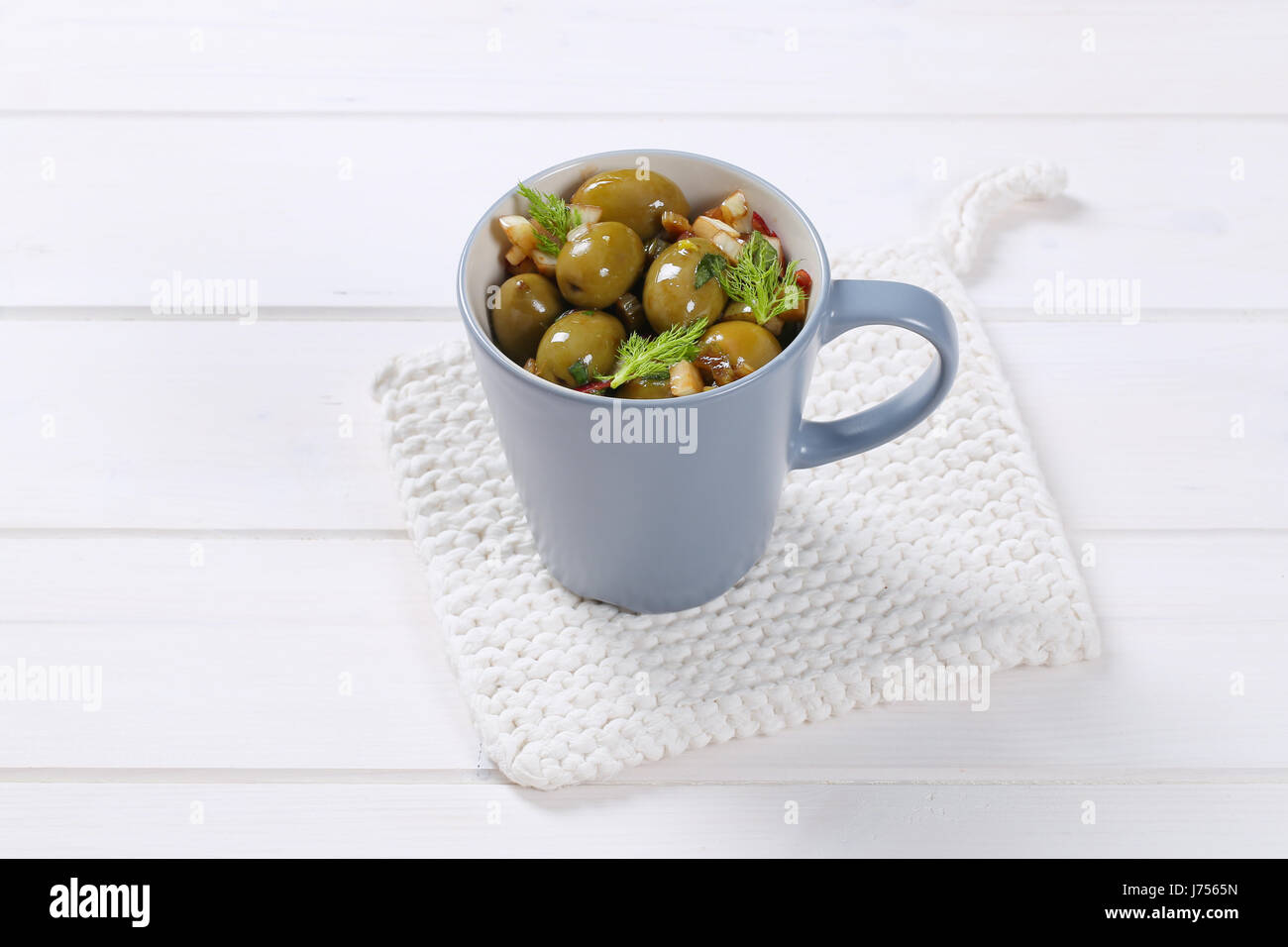 cup of marinated green olives on white table mat Stock Photo - Alamy