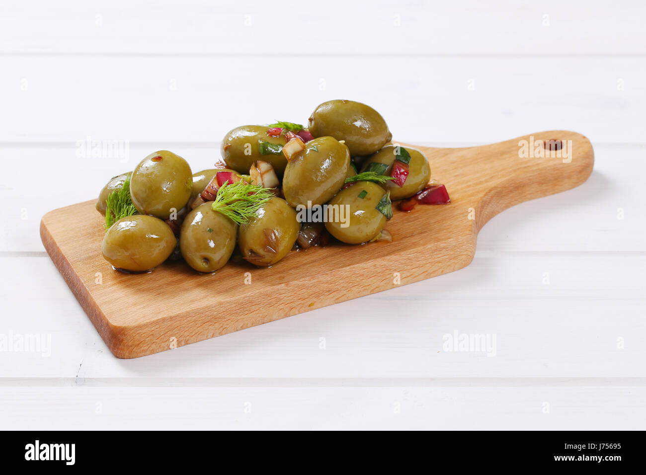 pile of marinated green olives on wooden cutting board Stock Photo - Alamy