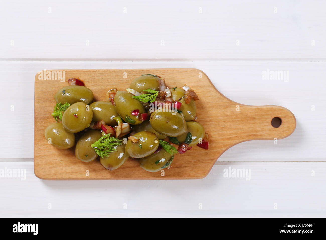 pile of marinated green olives on wooden cutting board Stock Photo - Alamy