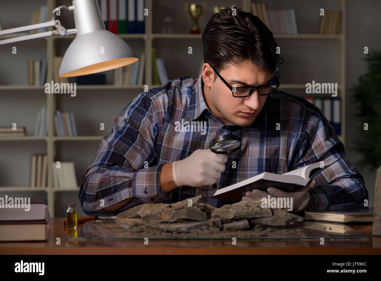 Archeologist working late night in office Stock Photo - Alamy