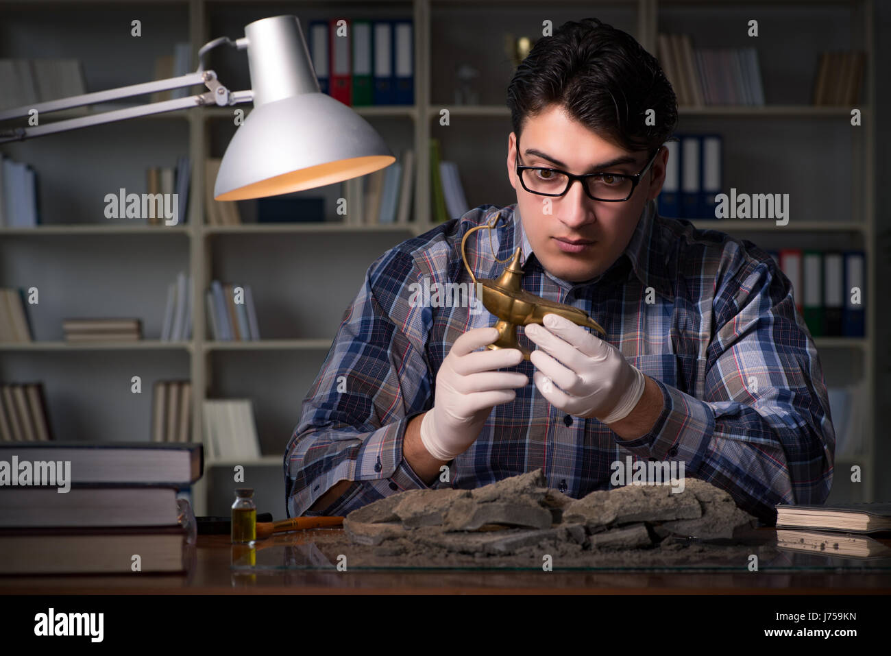 Archeologist working late night in office Stock Photo - Alamy