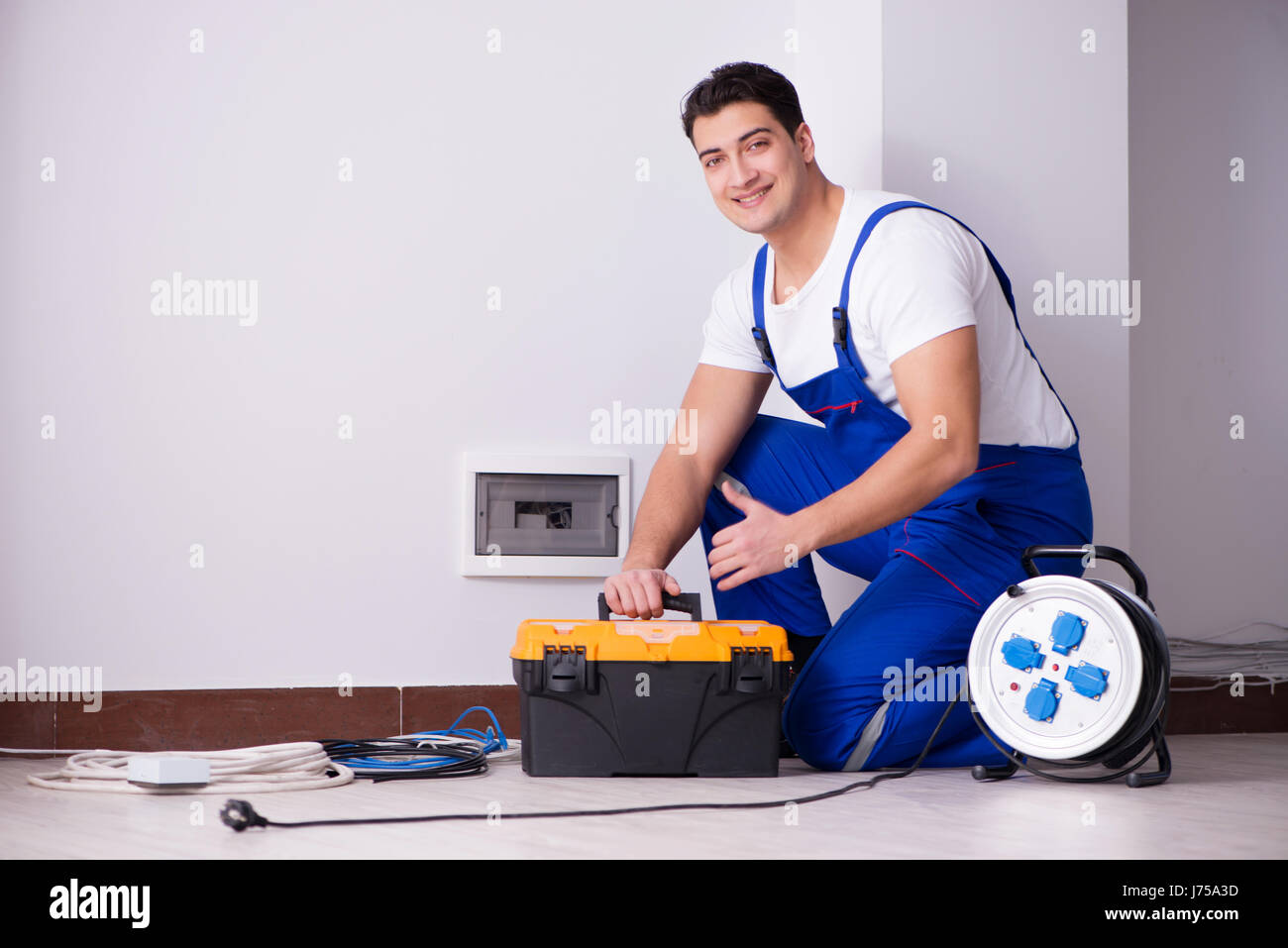 Young electrician working on socket at home Stock Photo - Alamy