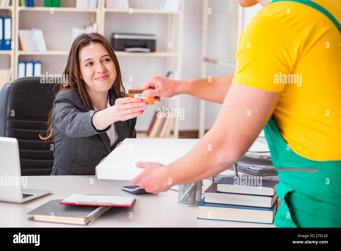 Postman delivering parcel to the office Stock Photo - Alamy