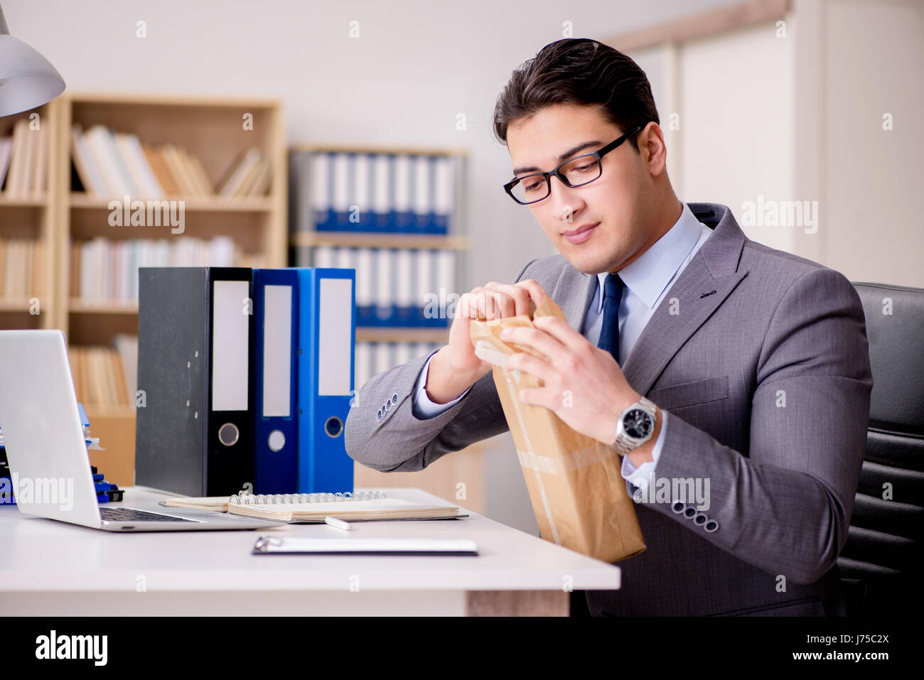 Businessman receiving parcel in office Stock Photo - Alamy