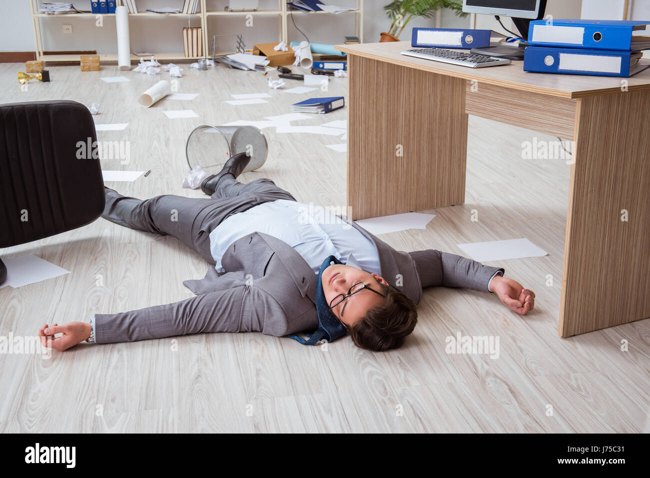 Businessman dead on the office floor Stock Photo - Alamy