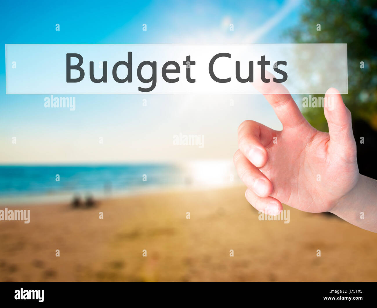 Budget Cuts - Hand pressing a button on blurred background concept ...