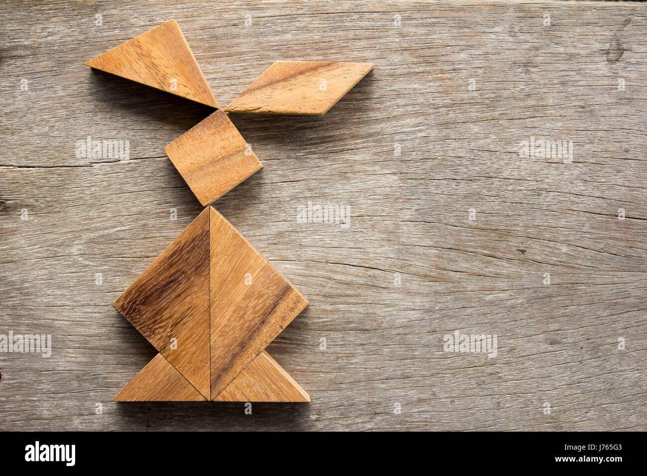 Chinese tangram puzzle in rabbit shape on wooden background (Concept ...