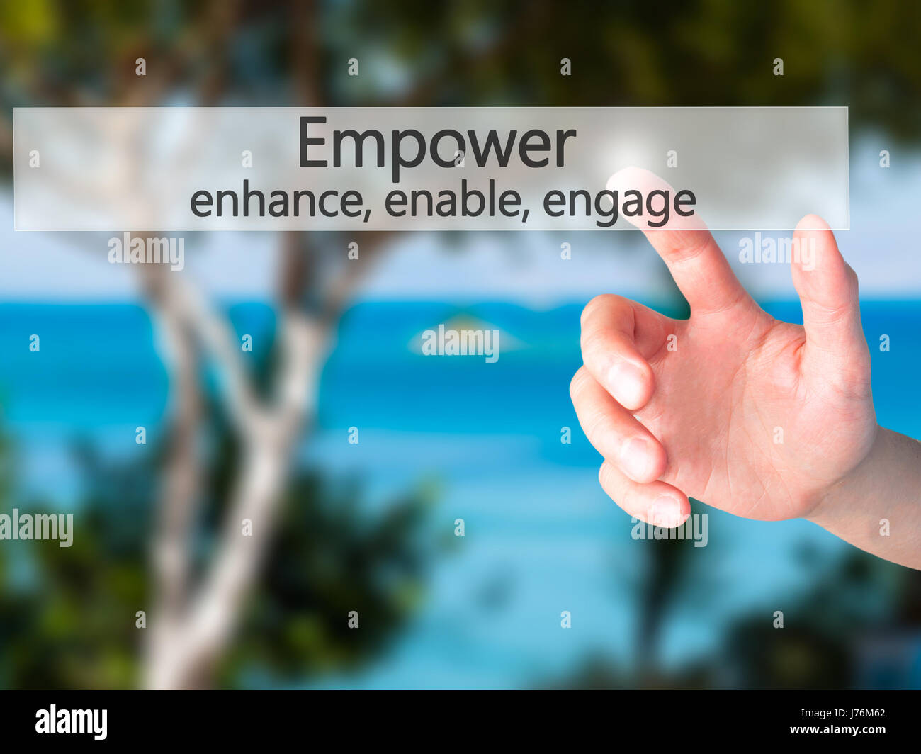 Empower enhance, enable, engage - Hand pressing a button on blurred ...