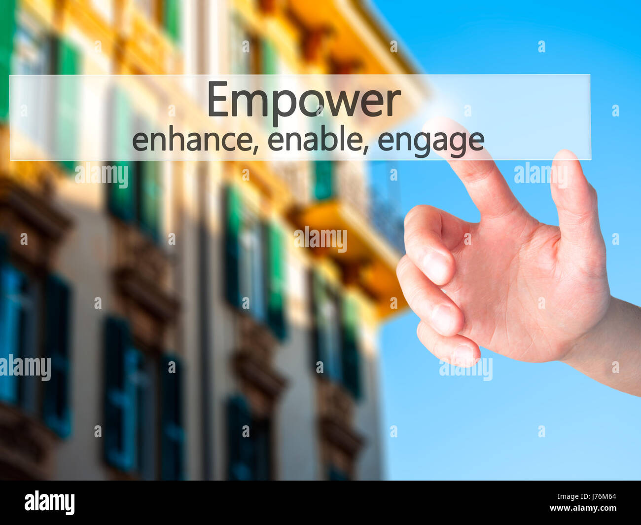 Empower enhance, enable, engage - Hand pressing a button on blurred ...