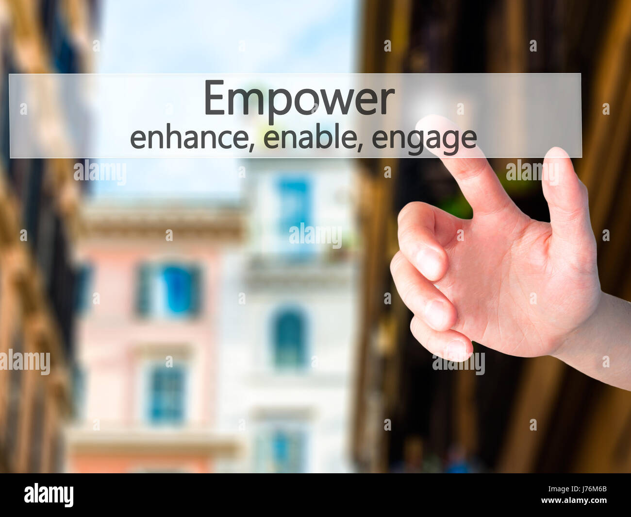 Empower enhance, enable, engage - Hand pressing a button on blurred ...