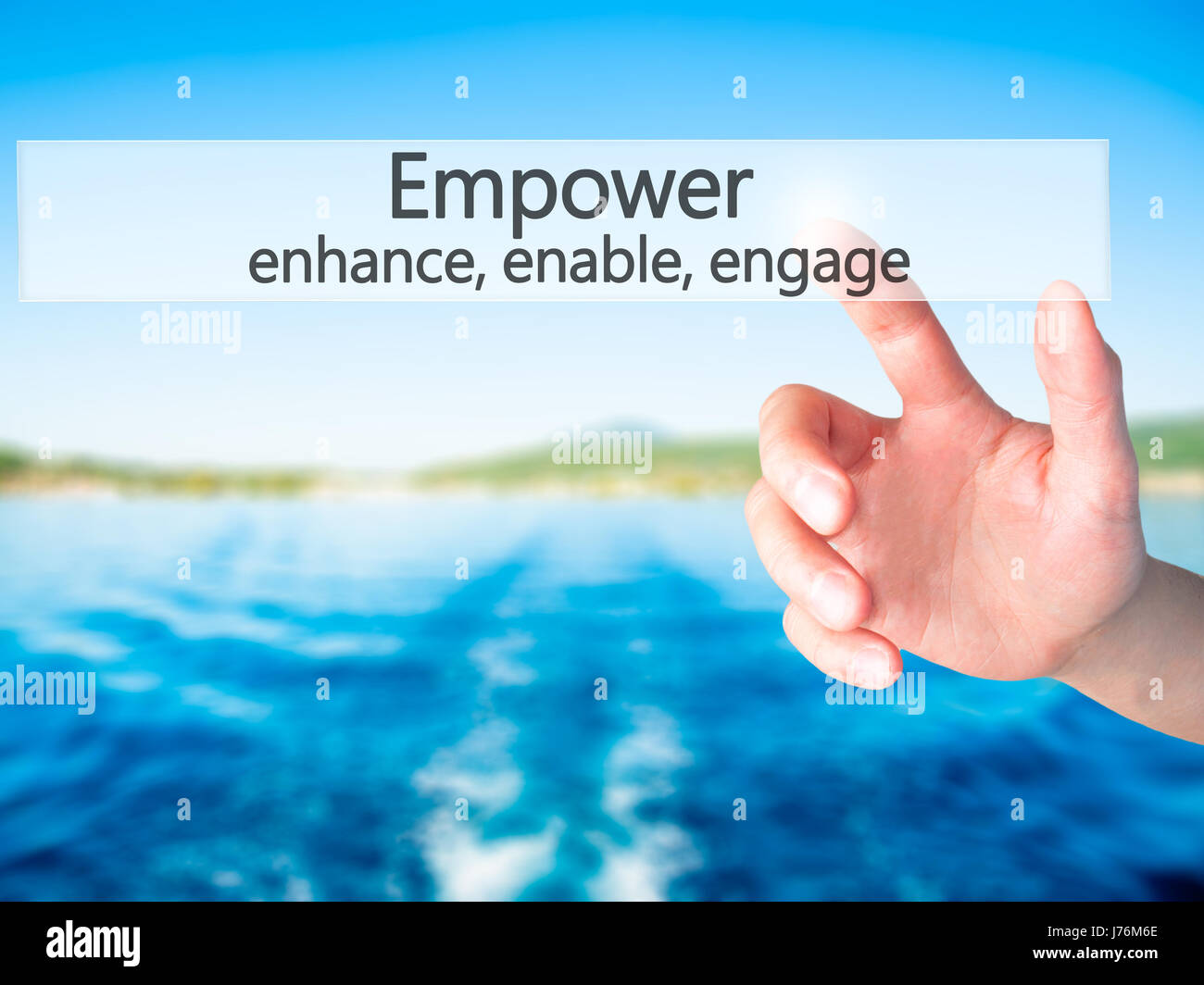 Empower enhance, enable, engage - Hand pressing a button on blurred ...