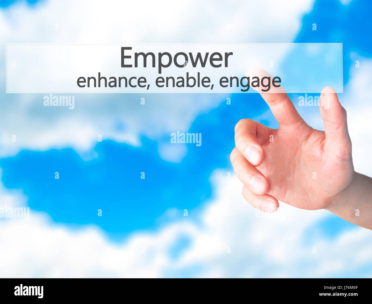 Empower enhance, enable, engage - Hand pressing a button on blurred ...