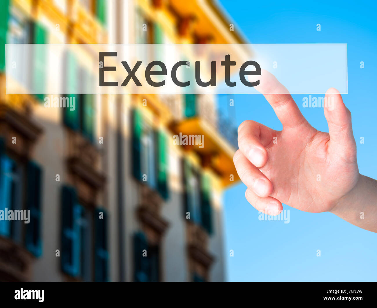 Execute - Hand pressing a button on blurred background concept ...