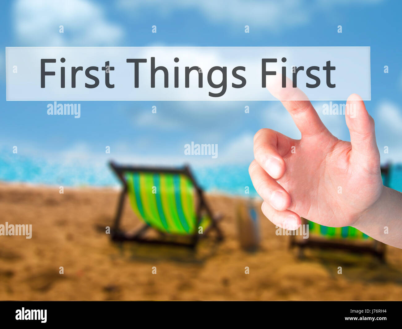 First Things First - Hand pressing a button on blurred background ...