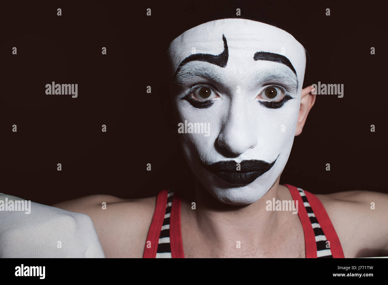 Portrait of a theatrical actor with mime makeup on a black background ...