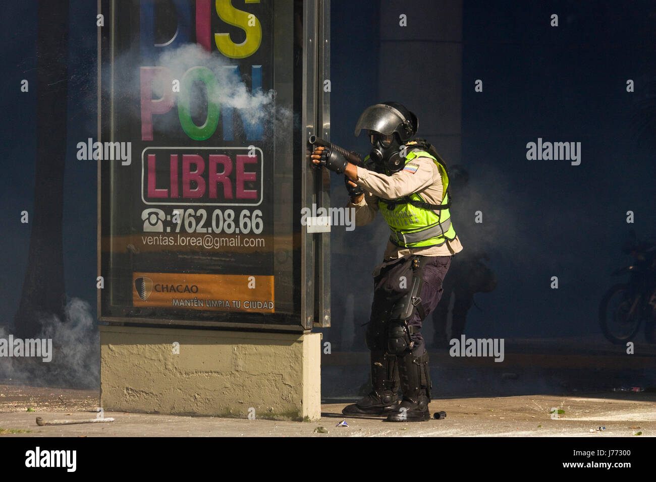 A police officer fires a tear gas canister during a protest against the ...