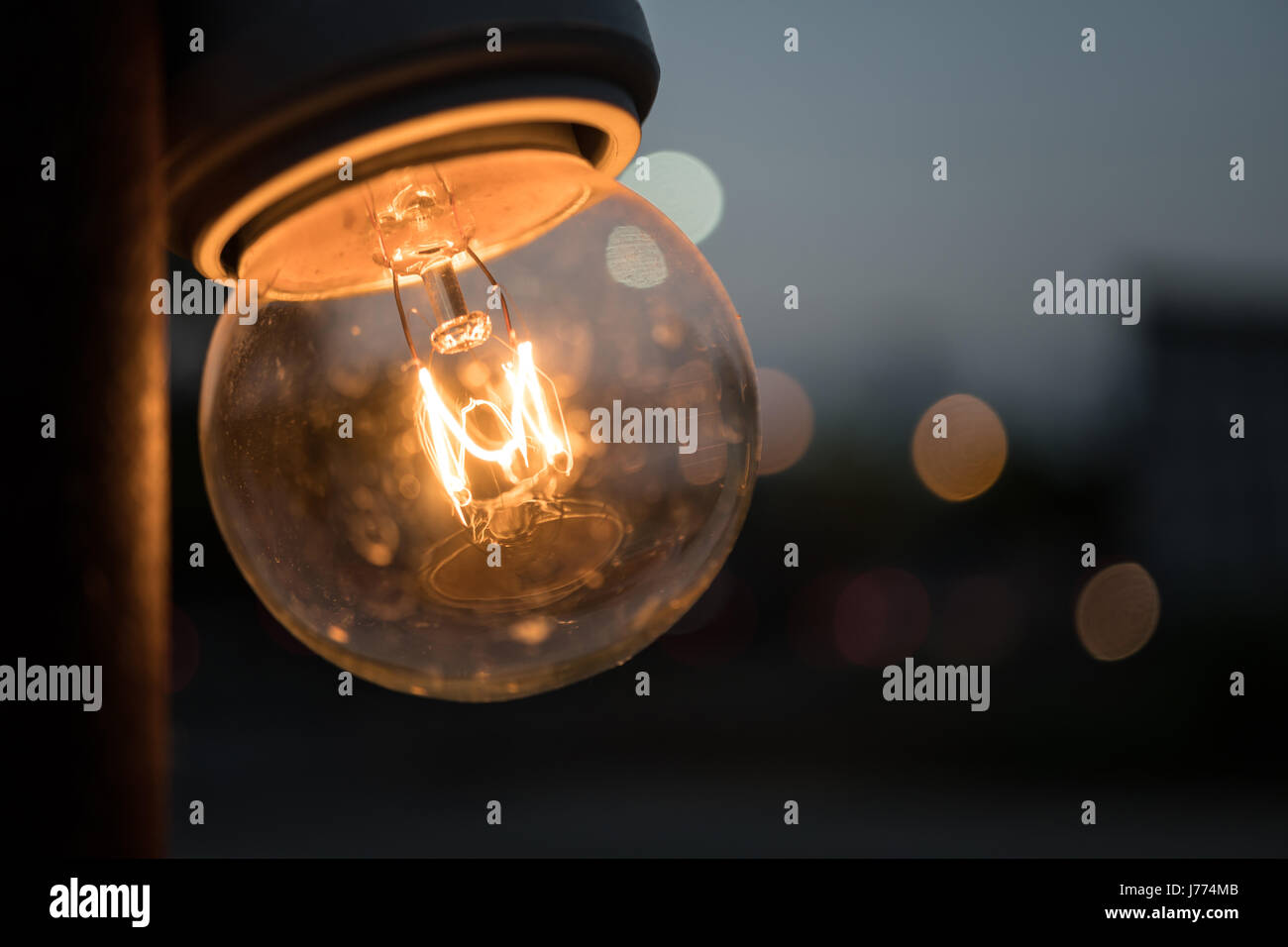 Glowing antique filament light bulb Stock Photo - Alamy