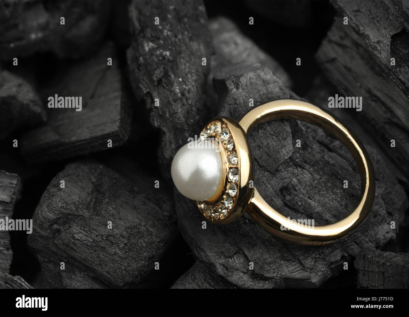 jewelry ring with diamond and pearl on black coal background Stock ...