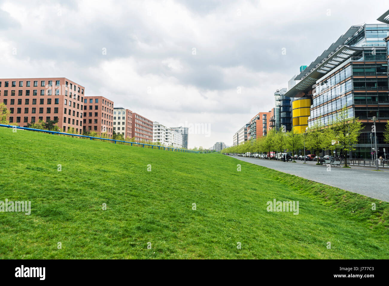 Grass lawn with modern apartment buildings and offices at your sides in ...