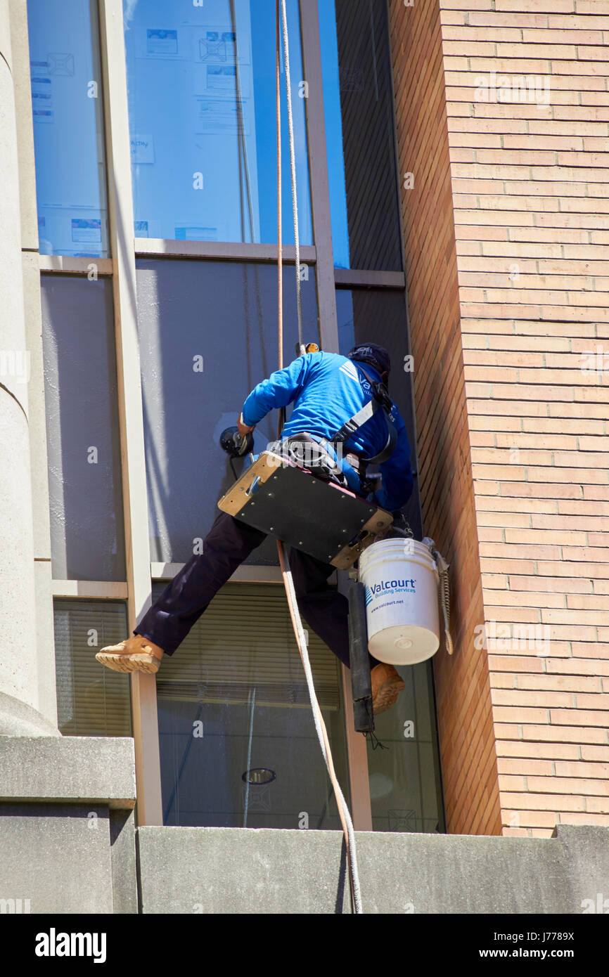 man cleaning windows using abseil rope techniques Washington DC USA ...