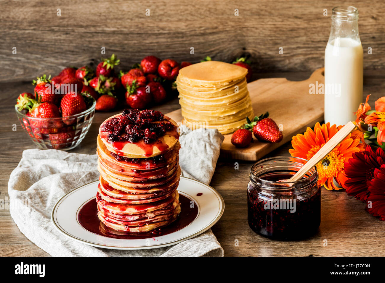Stack of homemade american pancakes served with jam and strawberries on ...