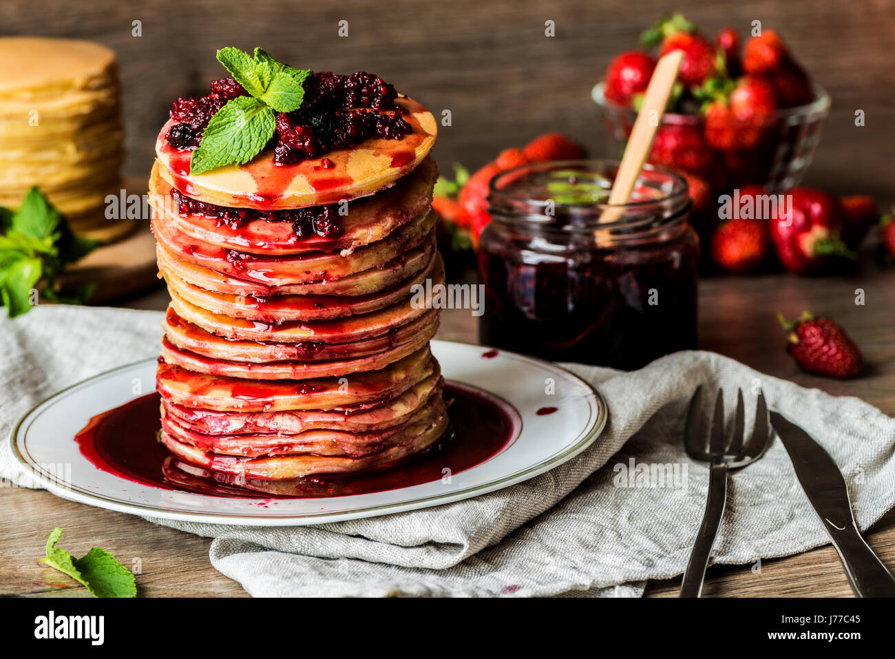 Stack of homemade american pancakes served with jam and strawberries on ...