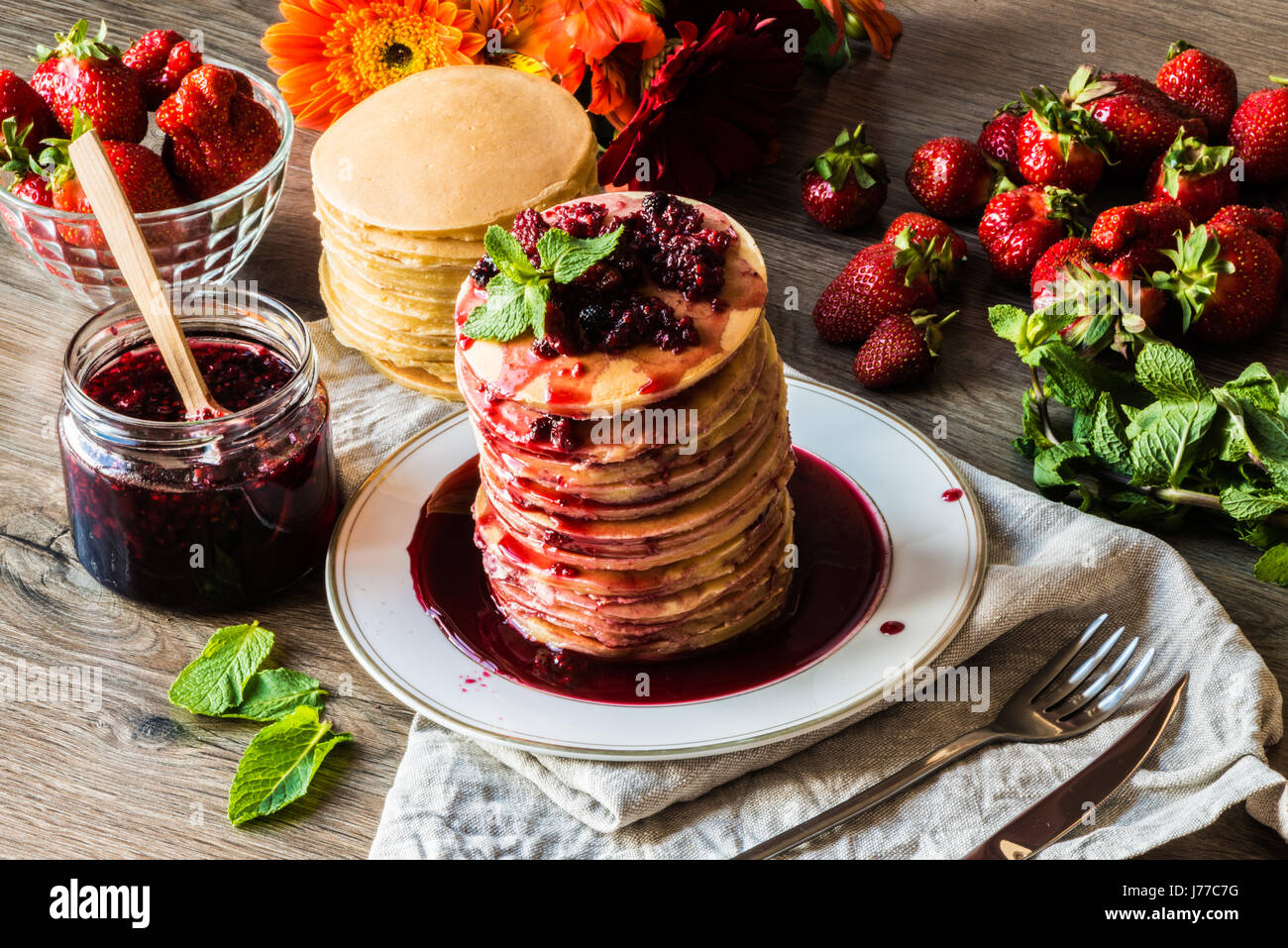 Stack of homemade american pancakes served with jam and strawberries on ...