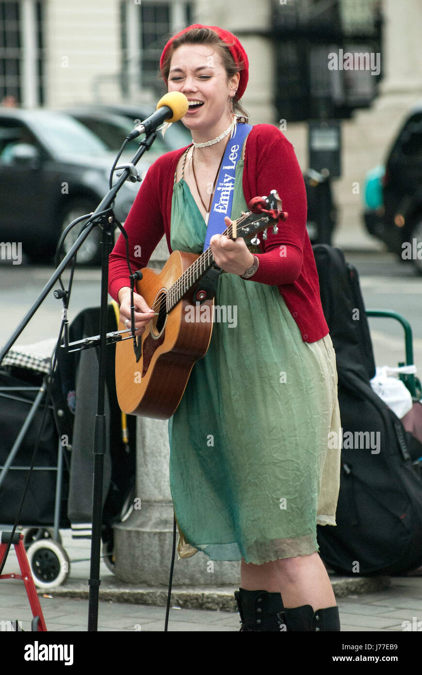 London, UK. 23rd May, 2017. Busker Emily Lee entertains the passing ...