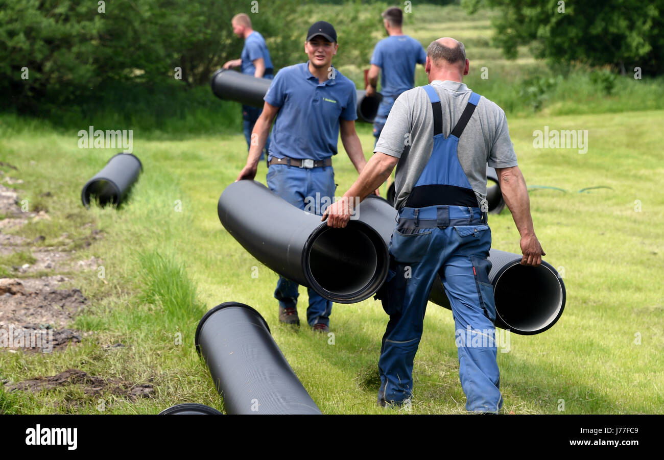 Wacken, Germany. 23rd May, 2017. Workers lay down empty pipes in the ...