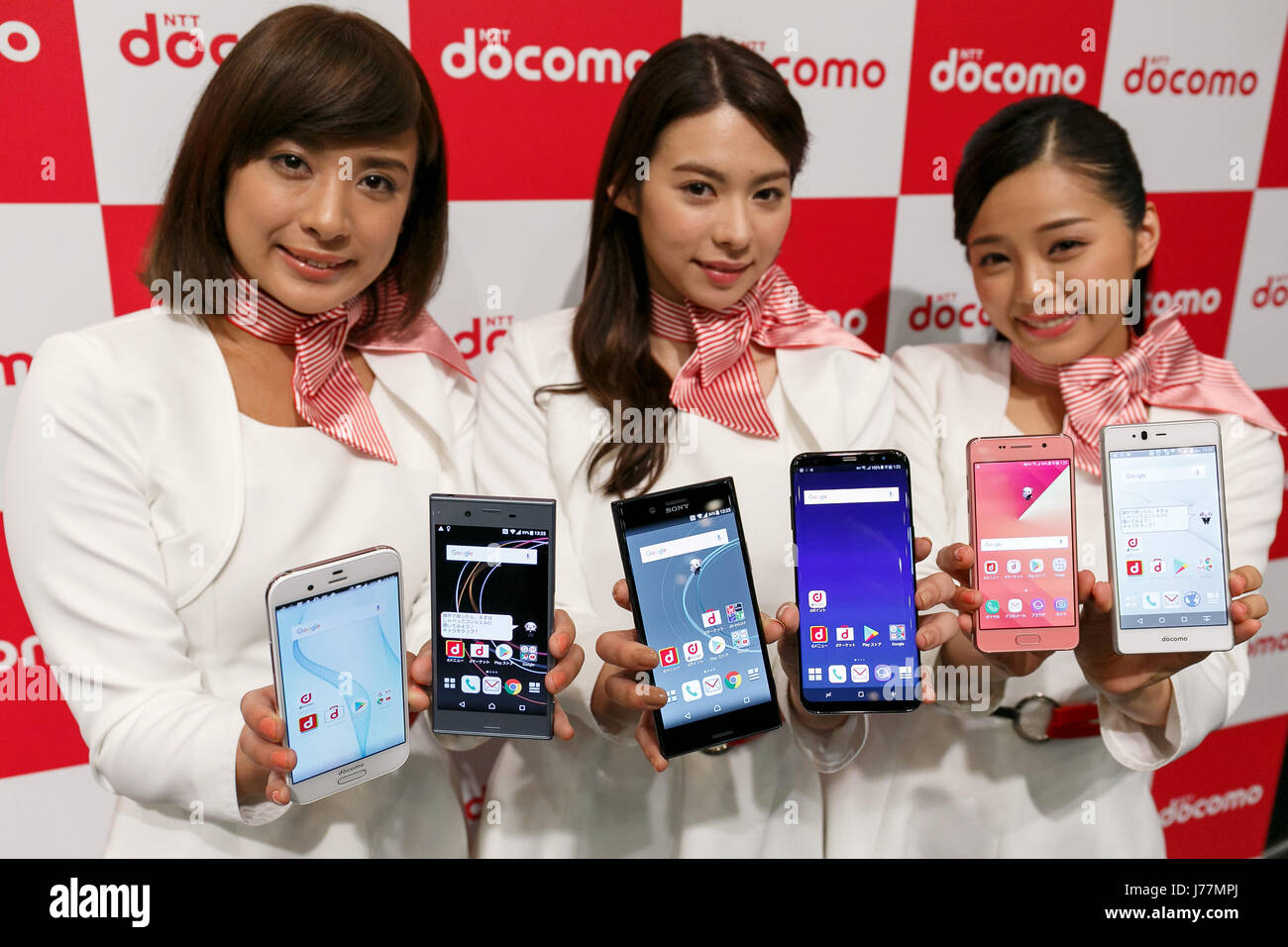 Models hold DOCOMO new mobile devices during the summer lineup launch ...
