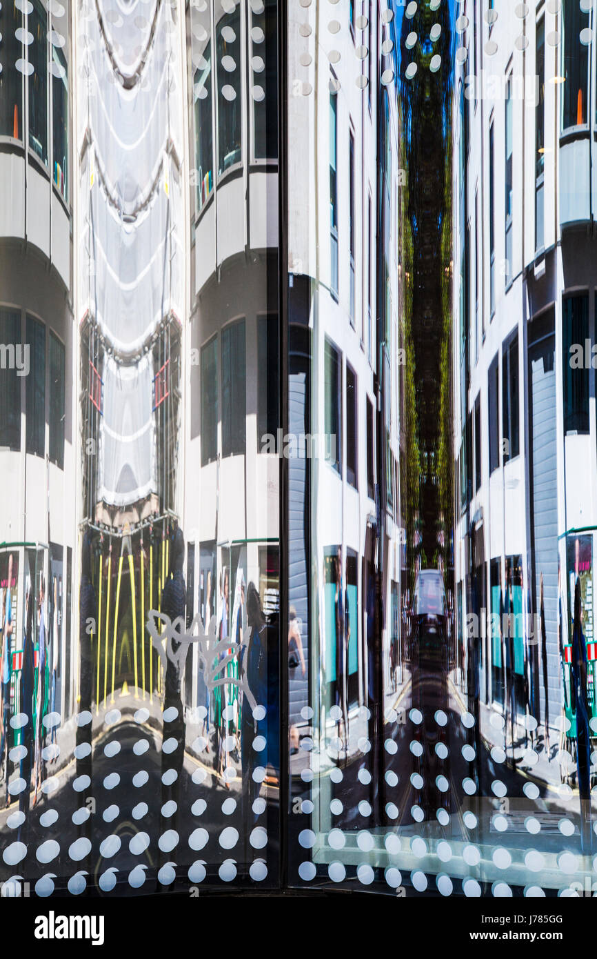 Distorted reflections in the window of a modern office building in Soho ...