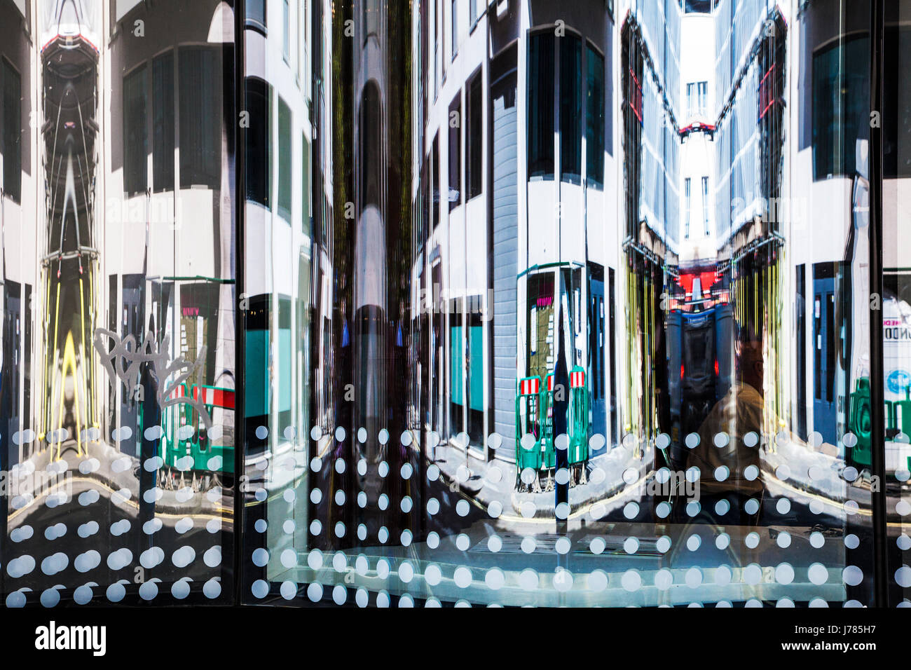 Distorted reflections in the window of a modern office building in Soho ...