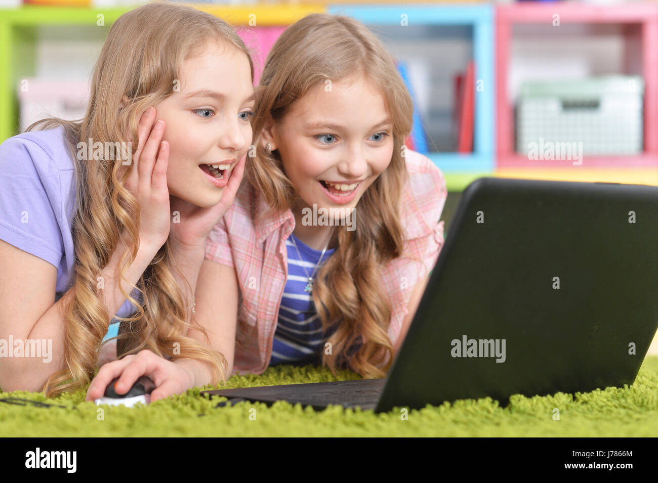 Portrait of two teenagers sisters using laptop Stock Photo - Alamy