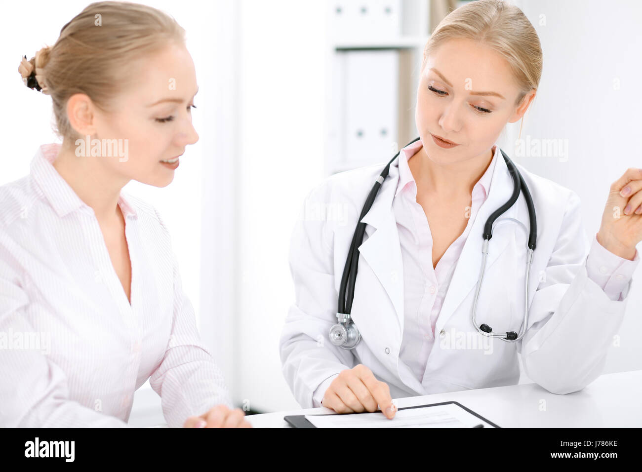 Doctor and patient sitting at the desk Stock Photo - Alamy