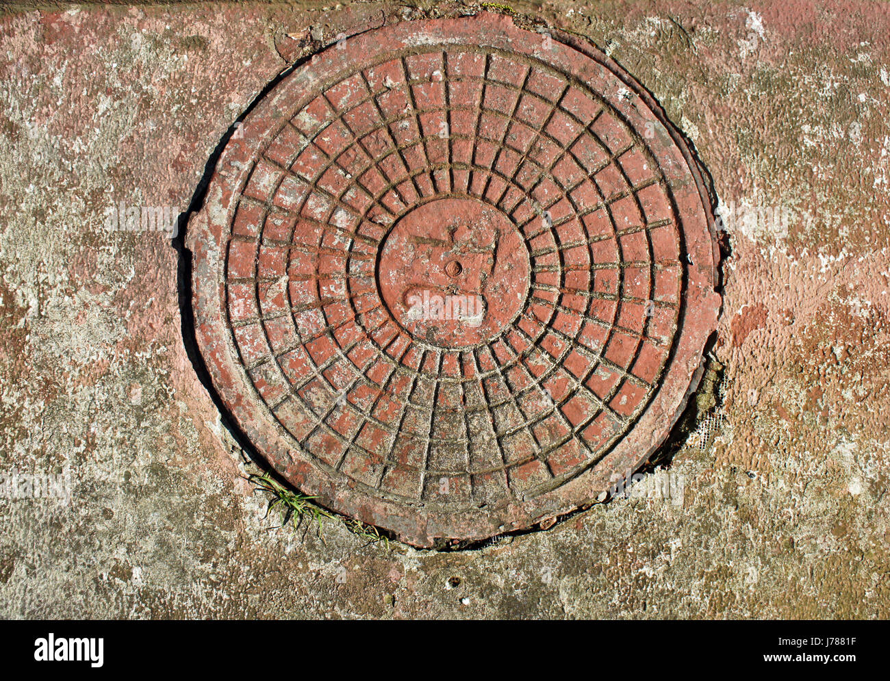 Old manhole, faded red colo Stock Photo - Alamy