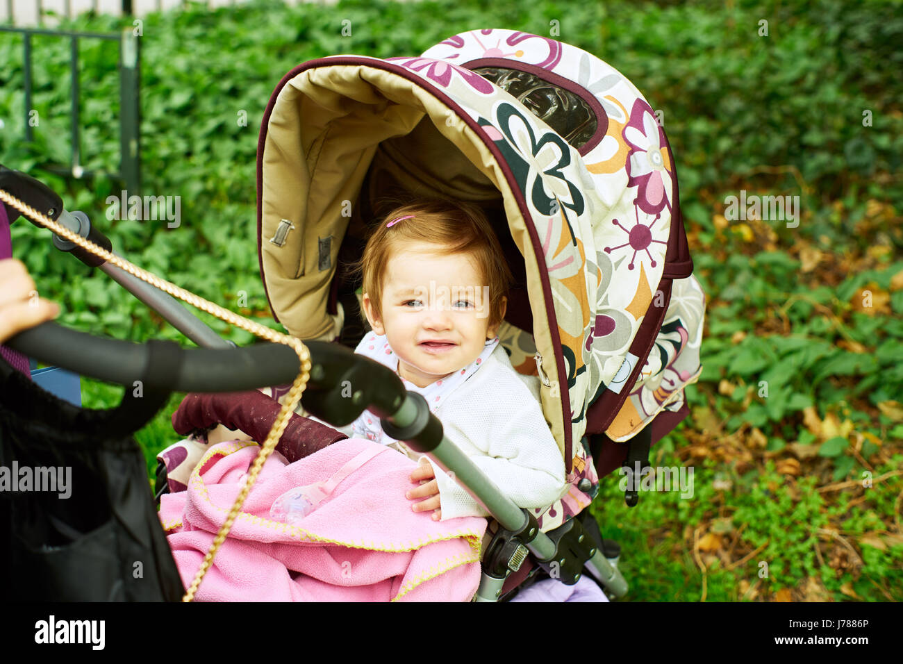 A baby sitting in a pram outdoors Stock Photo - Alamy