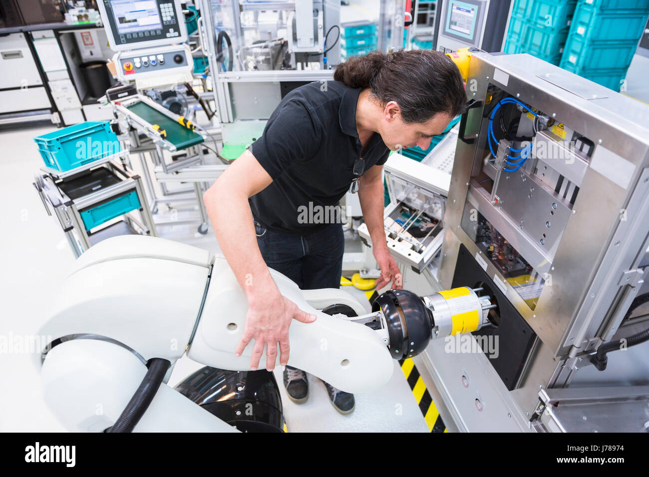 Man with assembly robot in factory Stock Photo - Alamy