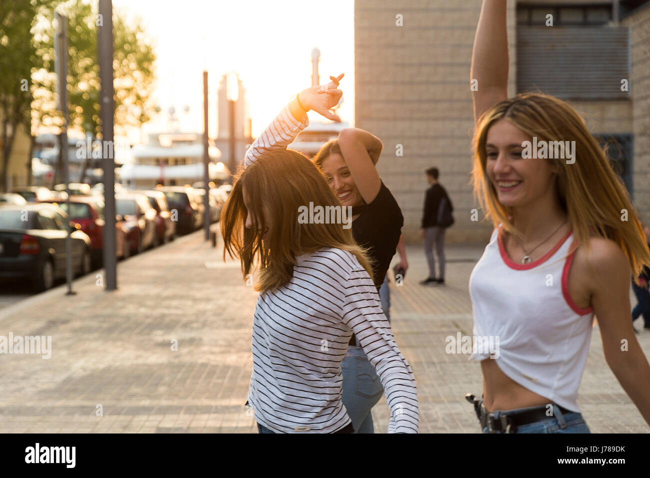 Three friends dancing on sidewalk Stock Photo - Alamy