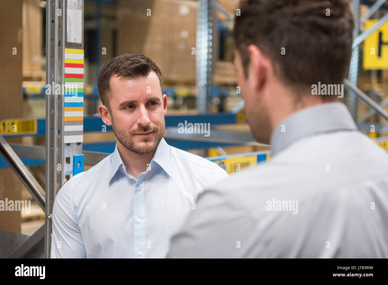 Two men in factory warehouse Stock Photo - Alamy