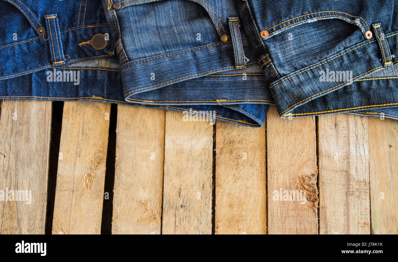 three jeans with wood background Stock Photo - Alamy