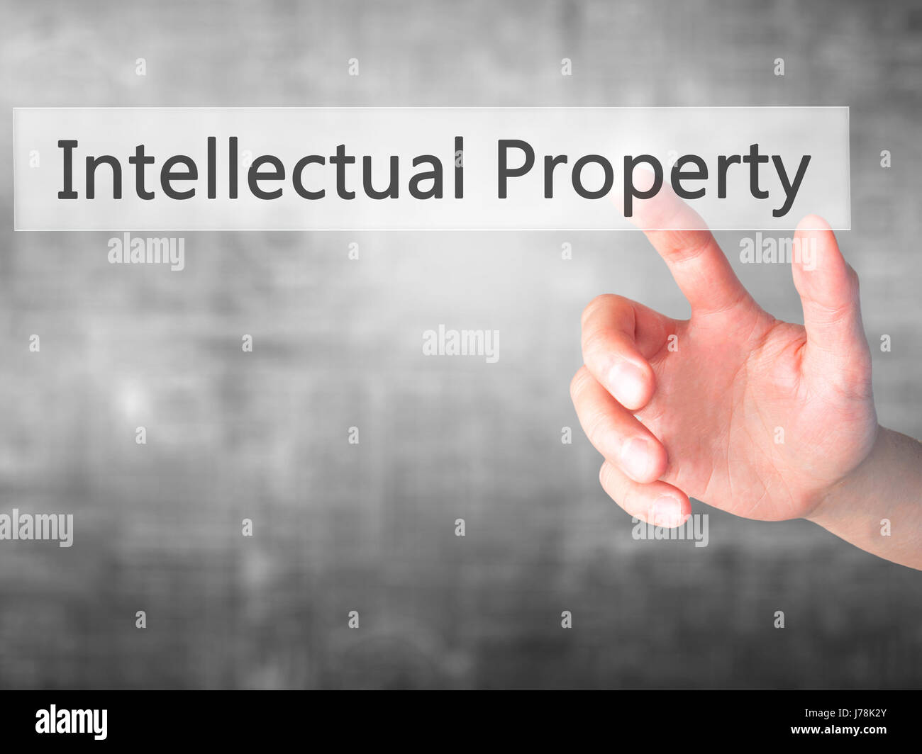 Intellectual Property - Hand pressing a button on blurred background ...