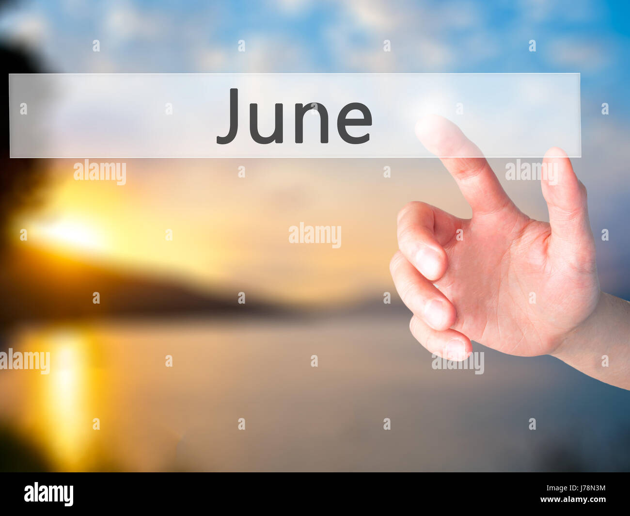 June - Hand pressing a button on blurred background concept . Business ...