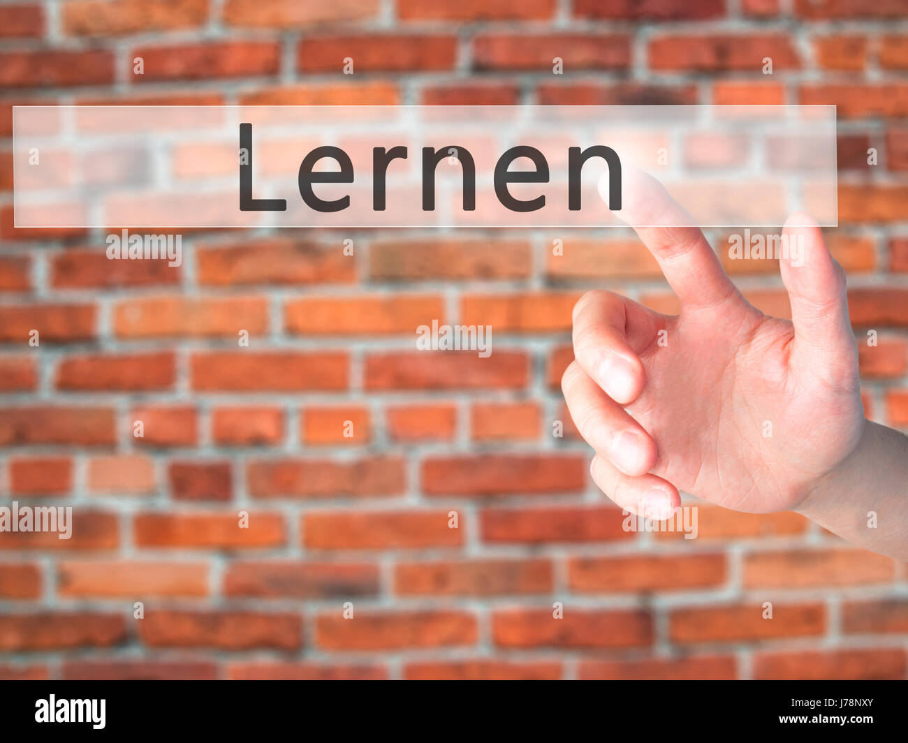 Lernen (Learn in German) - Hand pressing a button on blurred background ...